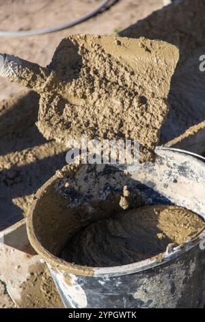 Male craftsman pouring concrete into concrete bricks. Selective focus ...