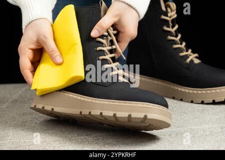 A person is cleaning leather casual boots with brush. Shoe shine and ...