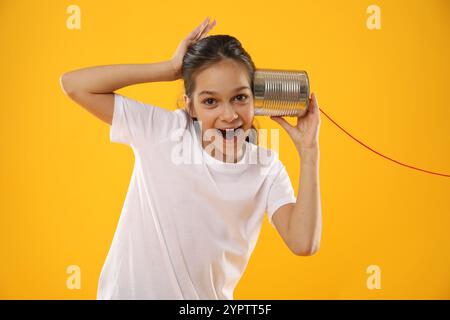Excited girl using tin can telephone on violet background Stock Photo ...