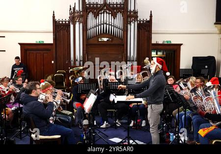 A brass or silver band playing Christmas music carols, outdoors, night ...