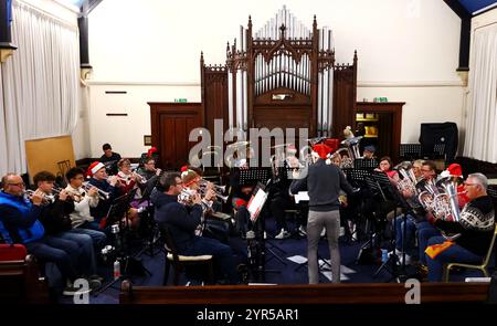 A brass or silver band playing Christmas music carols, outdoors, night ...