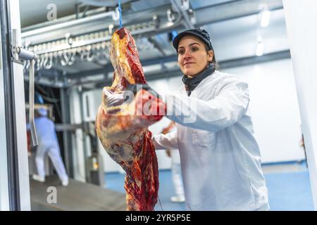 Caucasian adult woman unloading meat from truck in a cold storage room ...
