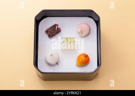 Wagashi in black stacked boxes on an orange table Stock Photo - Alamy