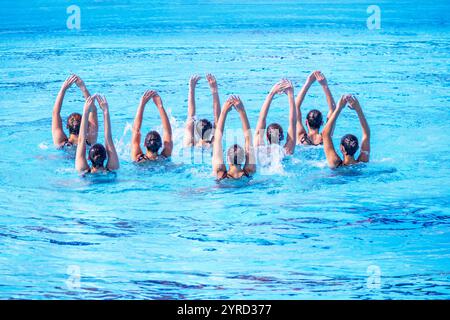 Artistic swimmers team performing synchronized choreographed routine in ...