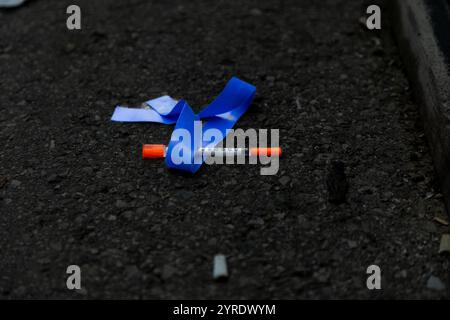 A discarded syringe is seen on a downtown path. The closure of safe ...