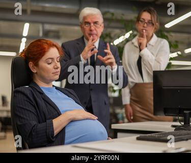 Elderly Caucasian man and woman giggling behind their sleeping pregnant ...