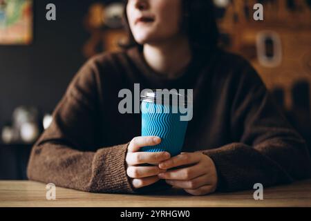 A person holds a cup of coffee while sitting at a cafe Stock Photo - Alamy