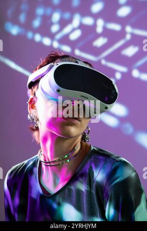 stylish female in metaverse in vr headset pressing the button in the ...