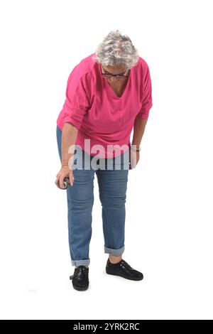 front view of a senior woman spray painting with arms raised on white ...