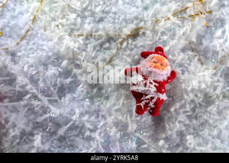 Miniature Santa Claus on a snowy background with golden elements ...