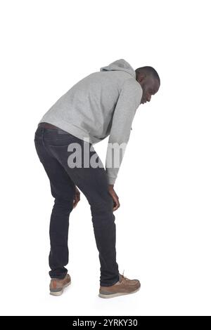 back view of a man crouched down and looking the floor on white ...