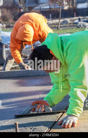 Detroit, Michigan - Workers pour and finish concrete for walking paths ...