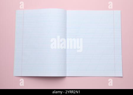 Open copybook on pink background, top view. School stationery Stock ...