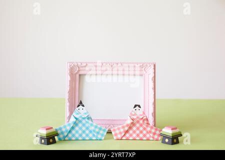 Hina dolls made of origami and a pink photo frame Stock Photo - Alamy