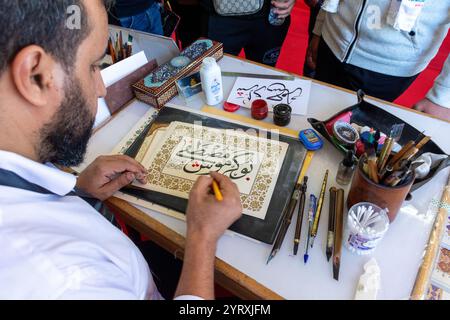 Male Arab calligraphist writing an Arabic name for a customer in Arabic ...