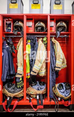 Firefighter gear neatly arranged in red lockers, showcasing helmets ...