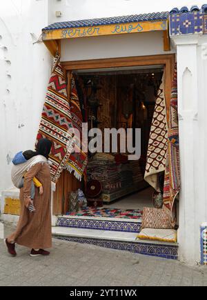 Moroccan woman carrying a child in the kasbah of Tangiers Stock Photo ...