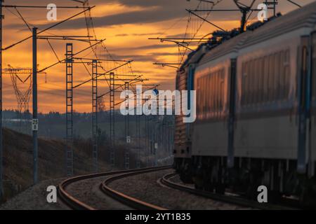 Fast passenger electric trains with sunset cloudy color near Neplachov ...