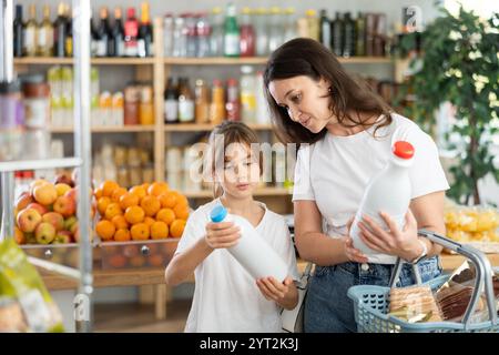 Checking expiration date of milk - mother and daughter checking qr code ...