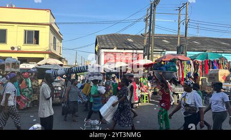 Accra, Ghana. 25th Nov, 2024. Passers-by, customers and traders visit ...