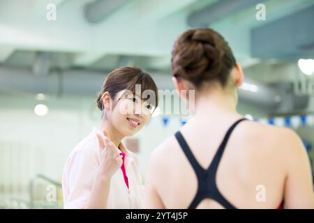 Swimming costume woman consulting instructor at pool Stock Photo - Alamy