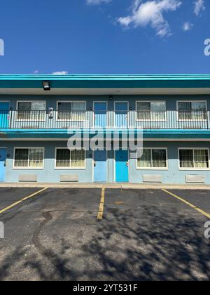 Abandoned two-story retro blue motel exterior under blue sky Stock ...