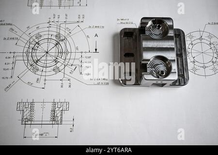 Precision-machined metal component lying on its technical drawing ...