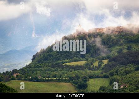 The hilltop village of Montefalcone Appennino shrouded by the lifting ...