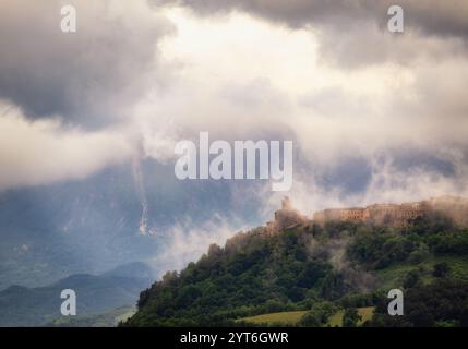 The hilltop village of Montefalcone Appennino shrouded by the lifting ...