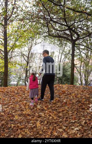 Child under an umbrella in the autumn park. Selective focus Stock Photo ...