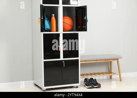 Lockers with personal belongings and bench in changing room at gym ...