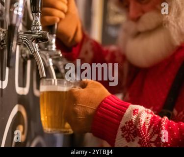 Santa Claus pouring beer from a keg at a bar Stock Photo - Alamy