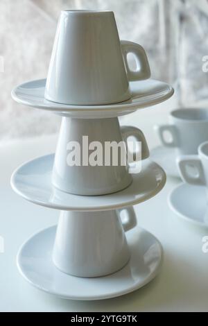 Stacked white coffee cups and saucers Stock Photo - Alamy