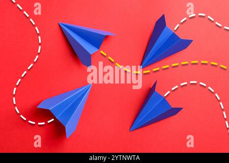 Red paper planes with flight paths on light blue background. Dashed ...