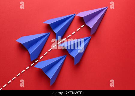 Purple paper plane with flight path on orange background. Dashed line ...