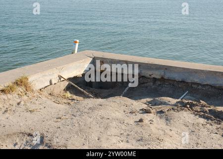 Corner view of eroded storm damaged seawall. Cracks in the seawall ...