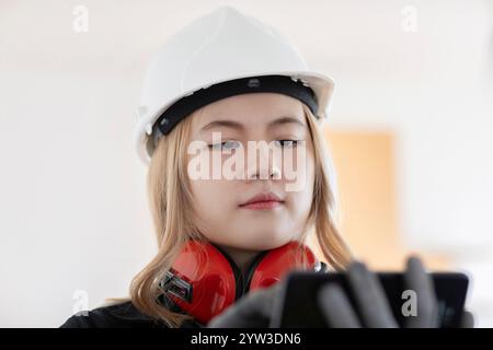 A worker in a construction helmet examines a document Stock Photo - Alamy