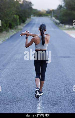 A back view of a fitness female walking on a street with a bag Stock ...