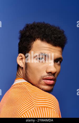 A handsome man showcases his charisma while looking over his shoulder ...