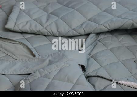 Quilted long jacket. Lying on the table. Close-up Stock Photo - Alamy