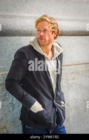 Young homeless man on light background Stock Photo - Alamy