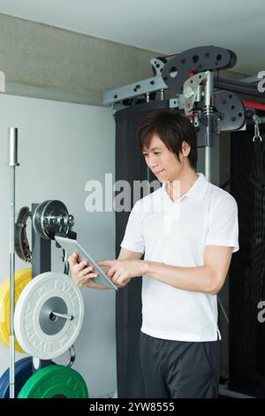 Male trainer operating tablet Stock Photo - Alamy