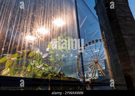 the ferris wheel in Rheinau harbour is reflected in the window of the ...