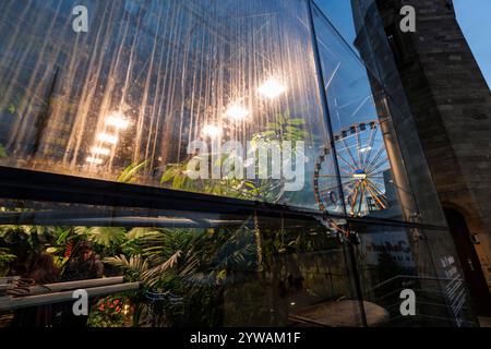 the ferris wheel in Rheinau harbour is reflected in the window of the ...