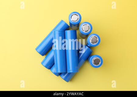 Many AA cell batteries on light grey background, top view. Space for ...