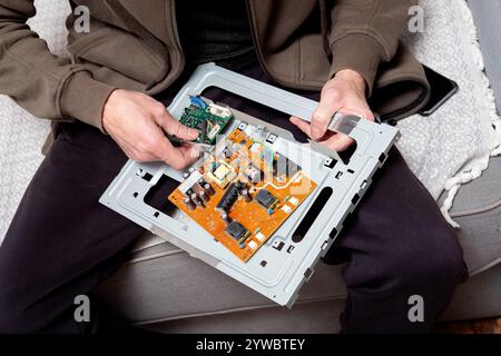 male hands repairing and disassembling the monitor. Open monitor with ...