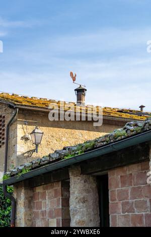 A metal weathervane rooster in the medieval walled town of ...