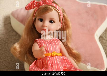 Beautiful doll and star shaped pillow in armchair indoors Stock Photo ...
