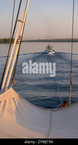 A dahabiya sailing on the river Nile Egypt, near the bank with palms ...