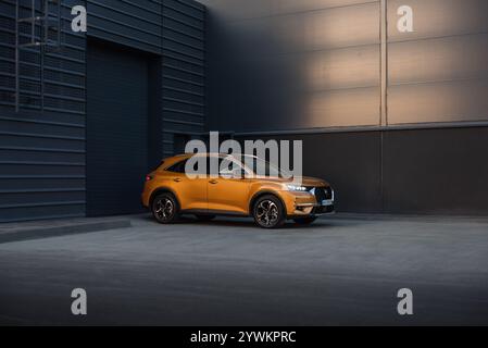 Light brown DS7 parked near dark grey warehouse at sunset. Three ...